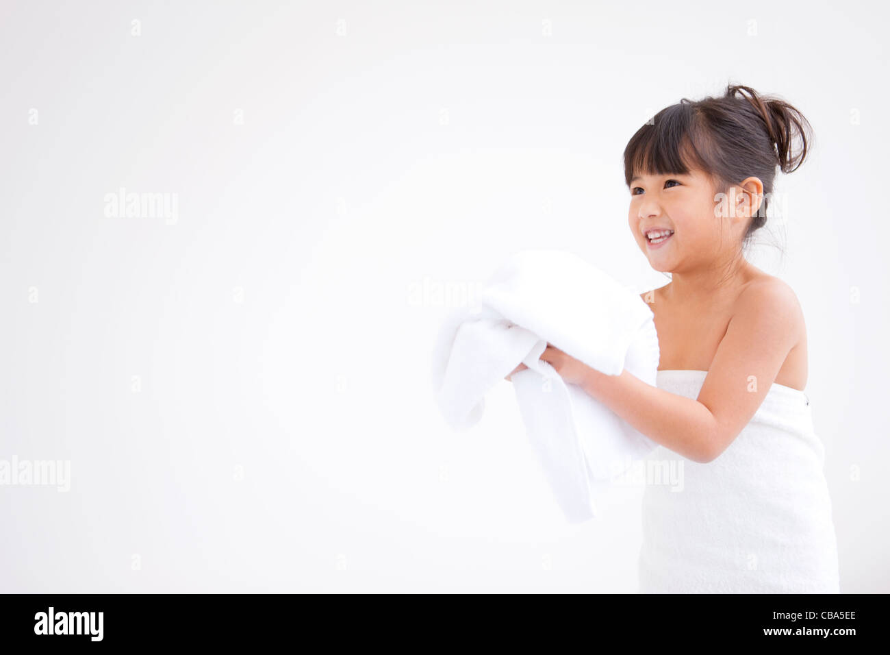 Girl holding a towel and smiling Stock Photo - Alamy