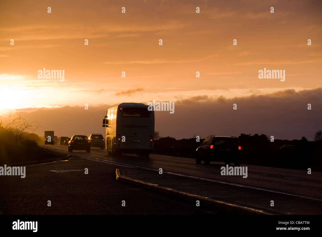 Coach on a road at sunset in uk Stock Photo - Alamy