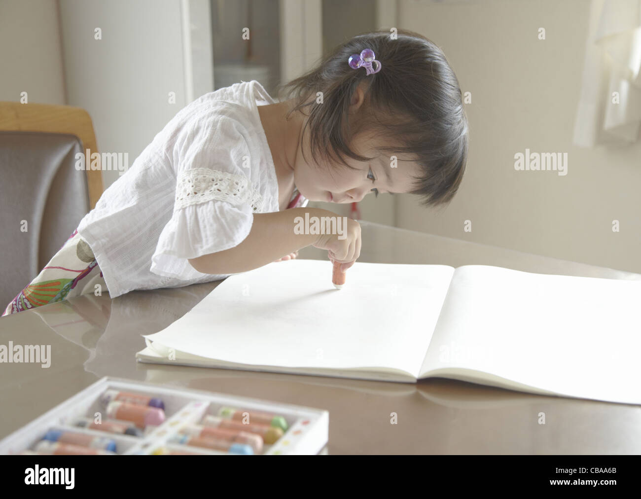 Girl drawing with crayons Stock Photo - Alamy