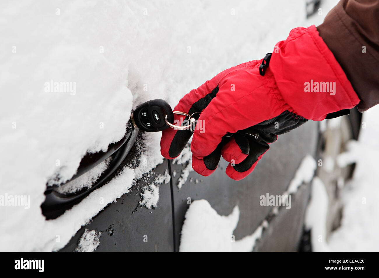 An illustrative photo of keys in the door of snow covered car, Prague ...