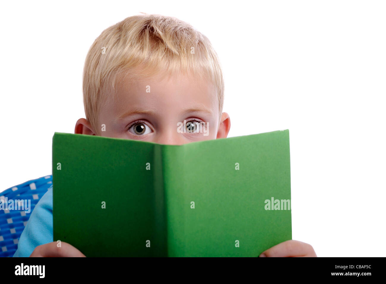 little boy with big eyes looking from over a book. isolated on white ...