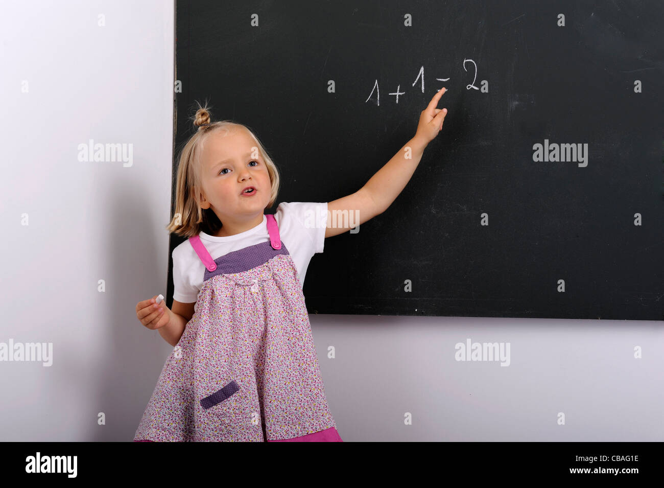 little girl writing on a chalkboard Stock Photo - Alamy
