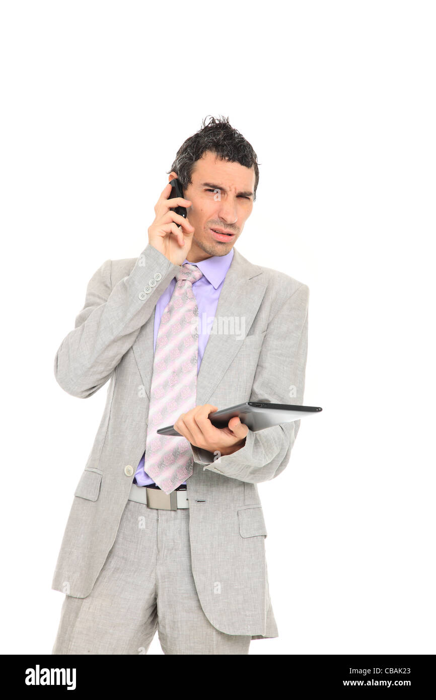 young business man standing using a tablet and talking on the phone ...