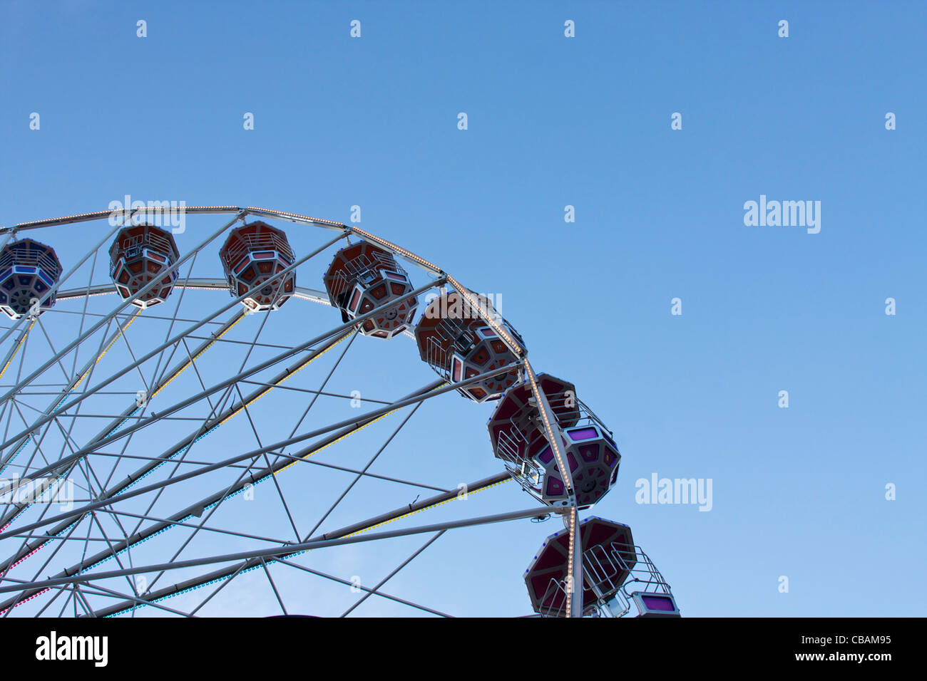 Partial view of large ferris wheel with blue sky and no clouds in ...