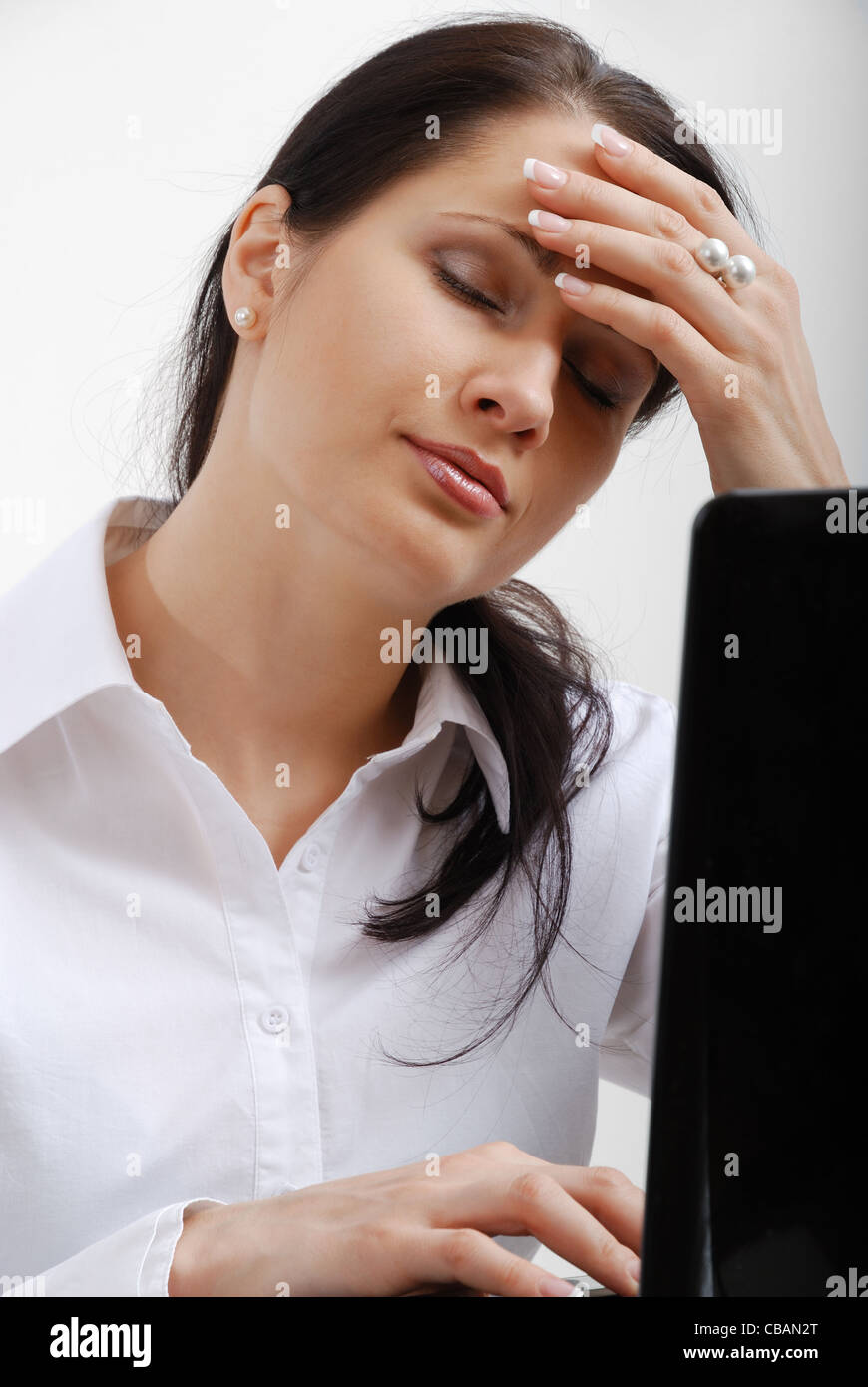 Tired woman near laptop Stock Photo - Alamy