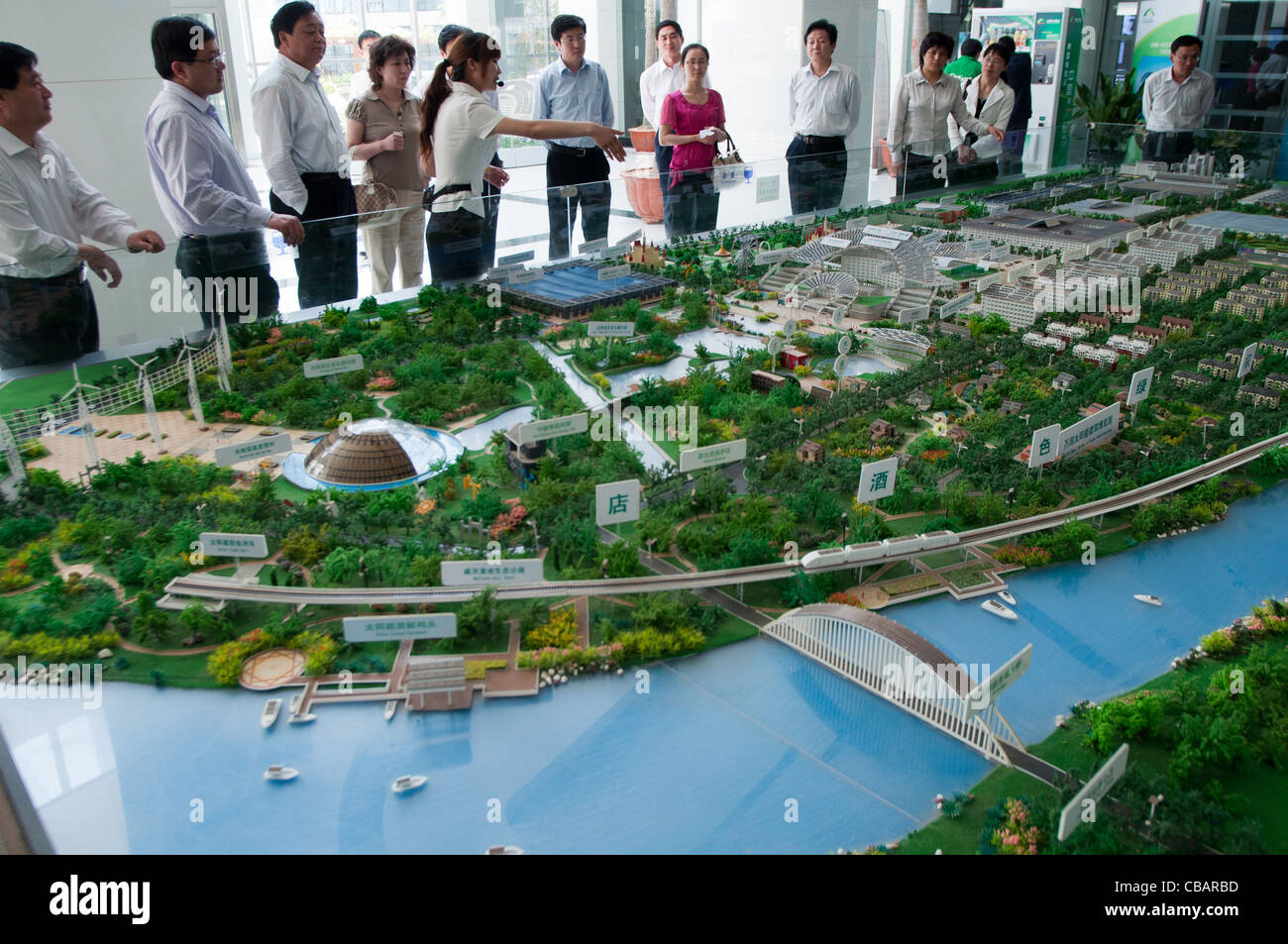 A hostess explains to the visitors the project of the China Solar ...