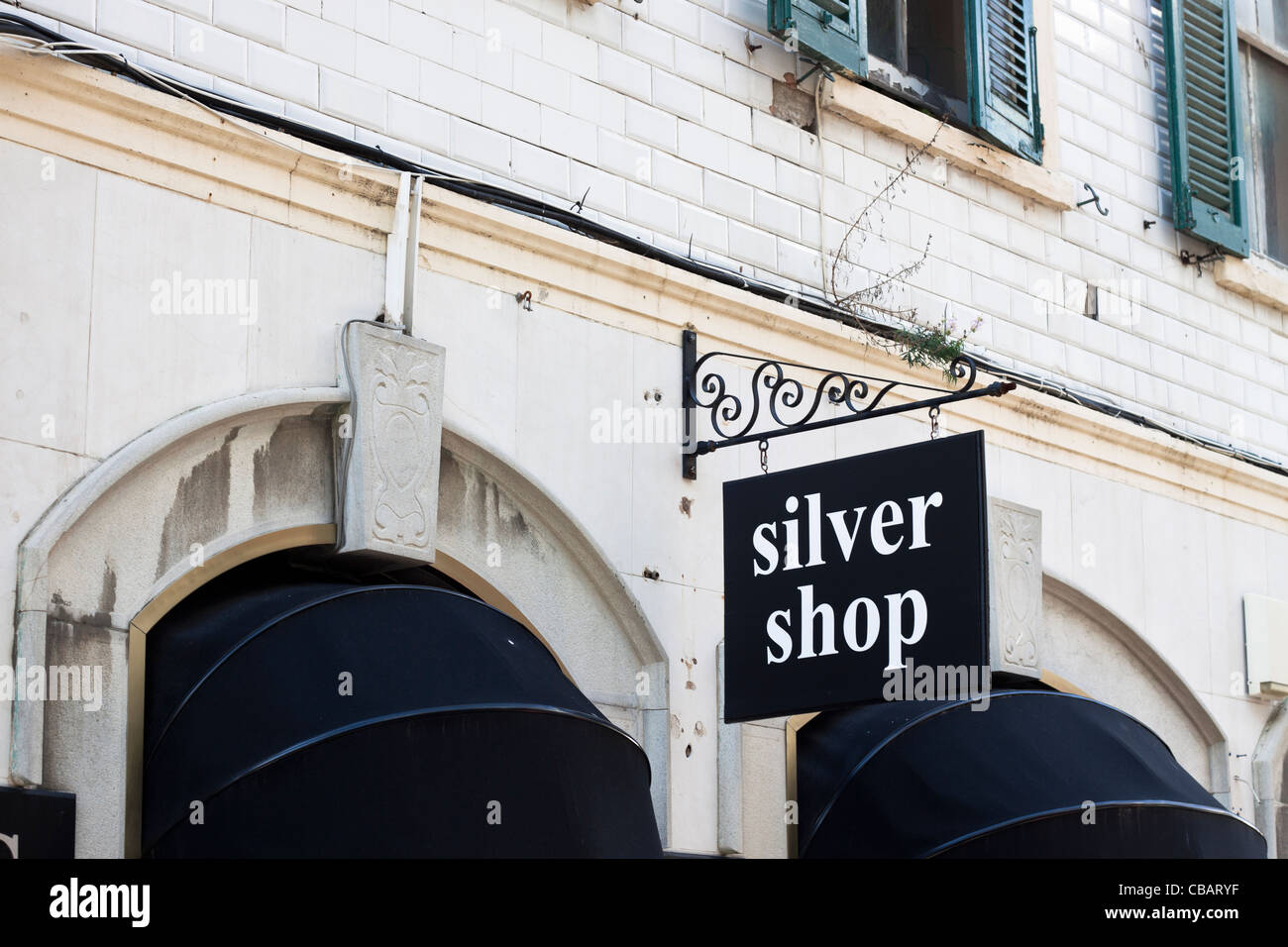 Detail of building with silver shop sign Stock Photo - Alamy