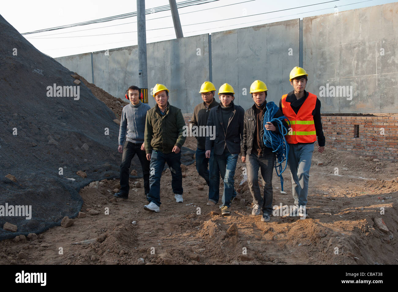 Construction workers walking at a construction site Stock Photo - Alamy