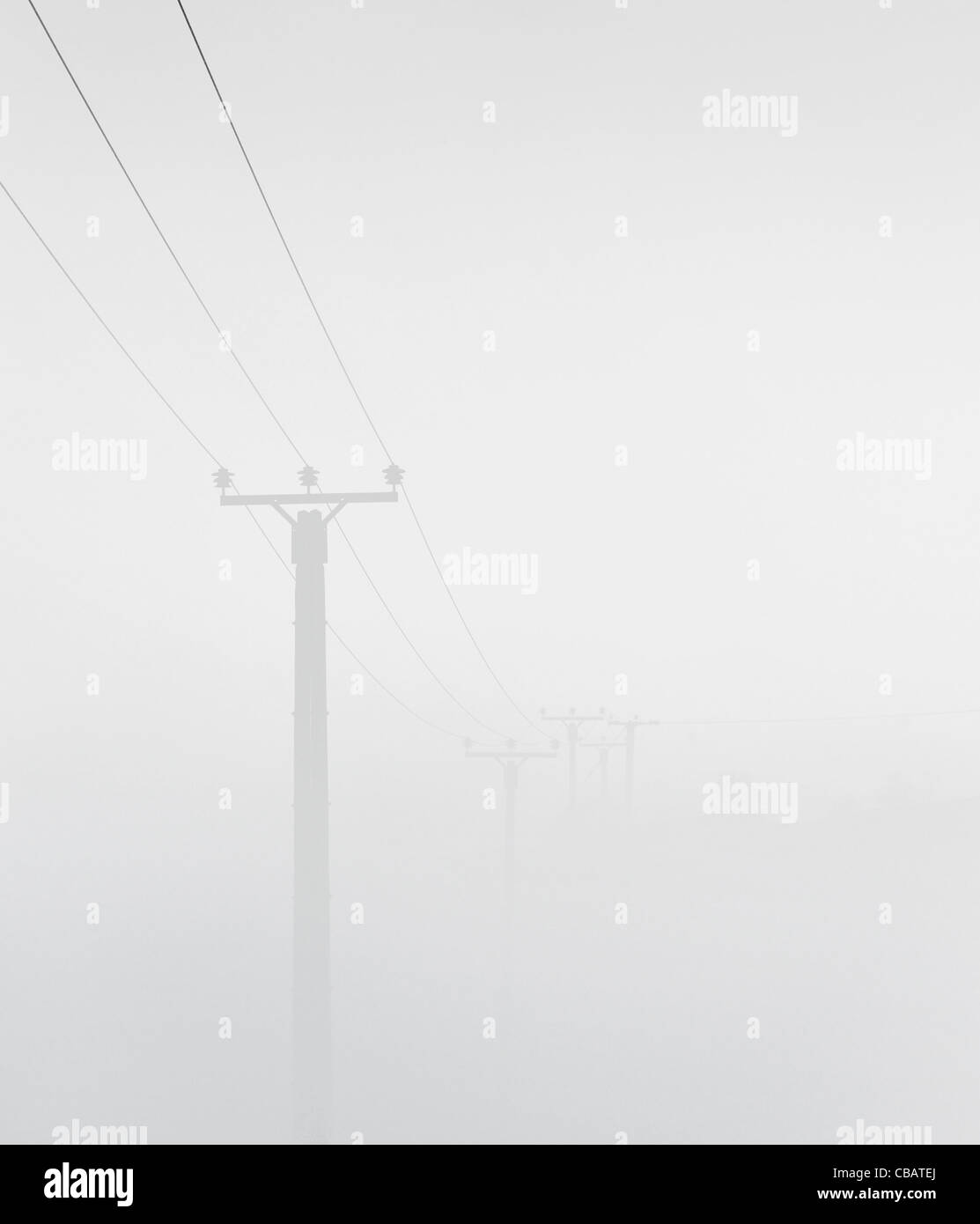 Power lines stretch across the hillside on a foggy cold morning in ...