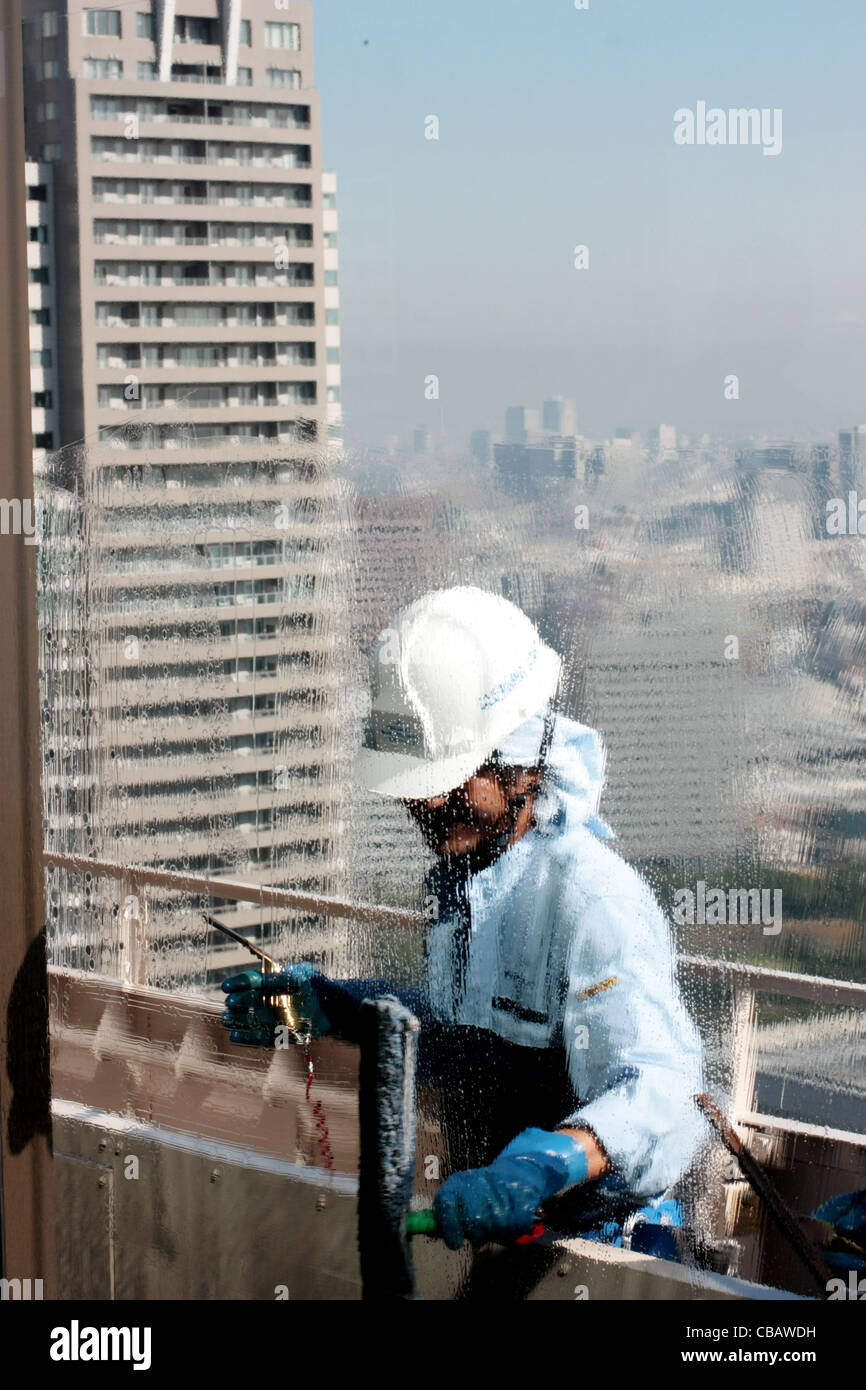 Japanese worker cleaning windows in Tokyo World Trade Center Stock ...