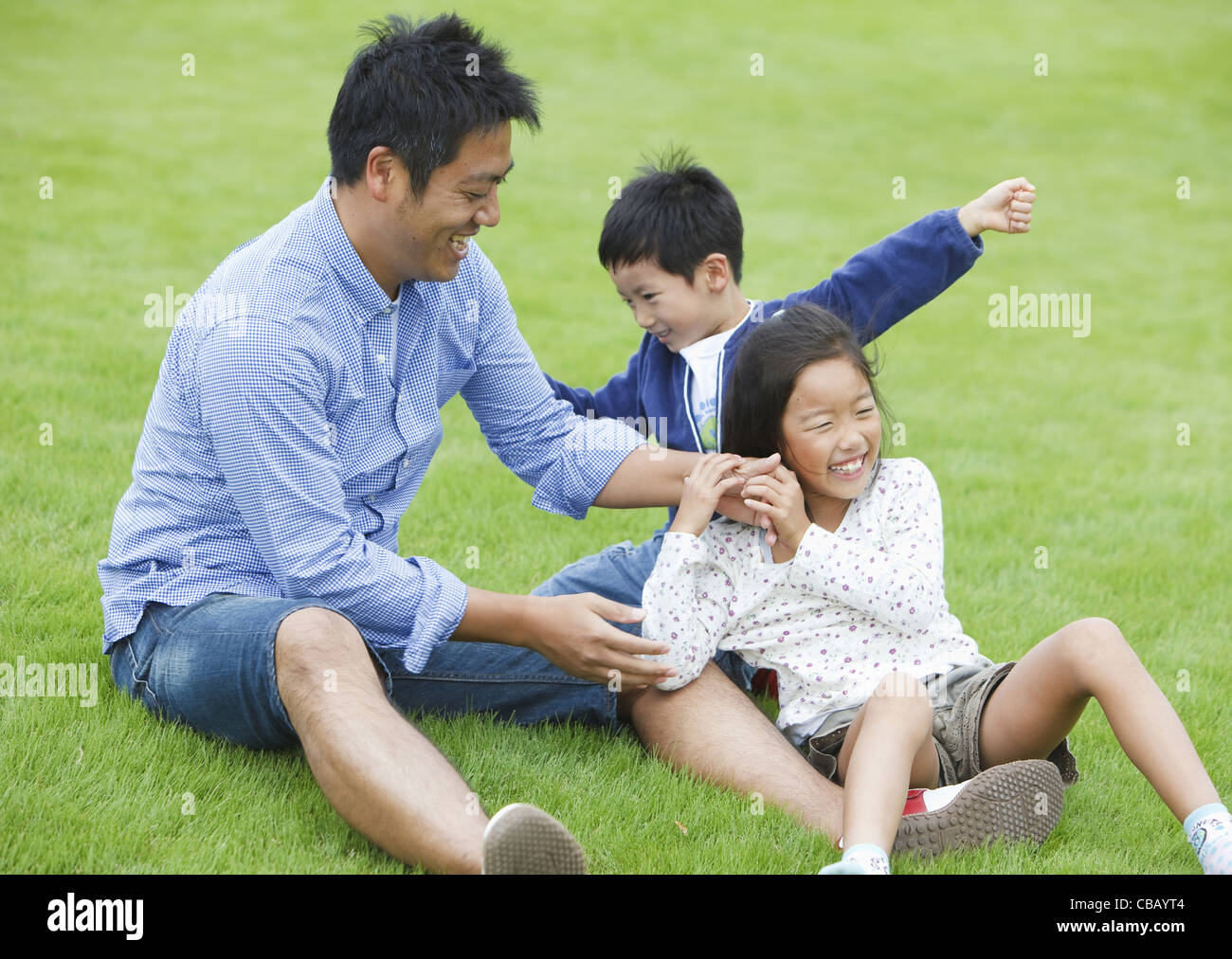 Father and children playing on grass Stock Photo - Alamy
