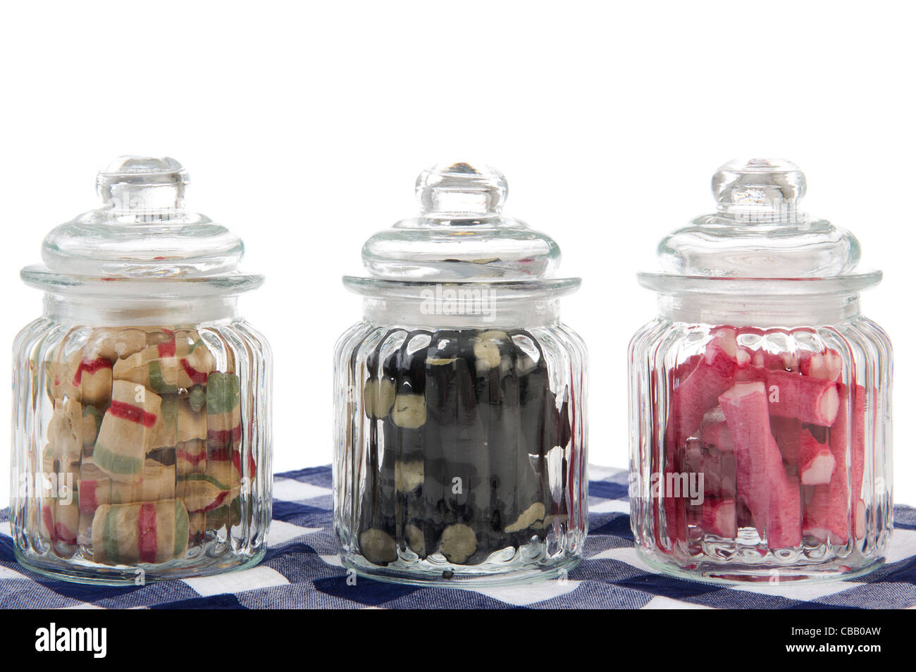 Three filled glass candy jars isolated over white background Stock ...
