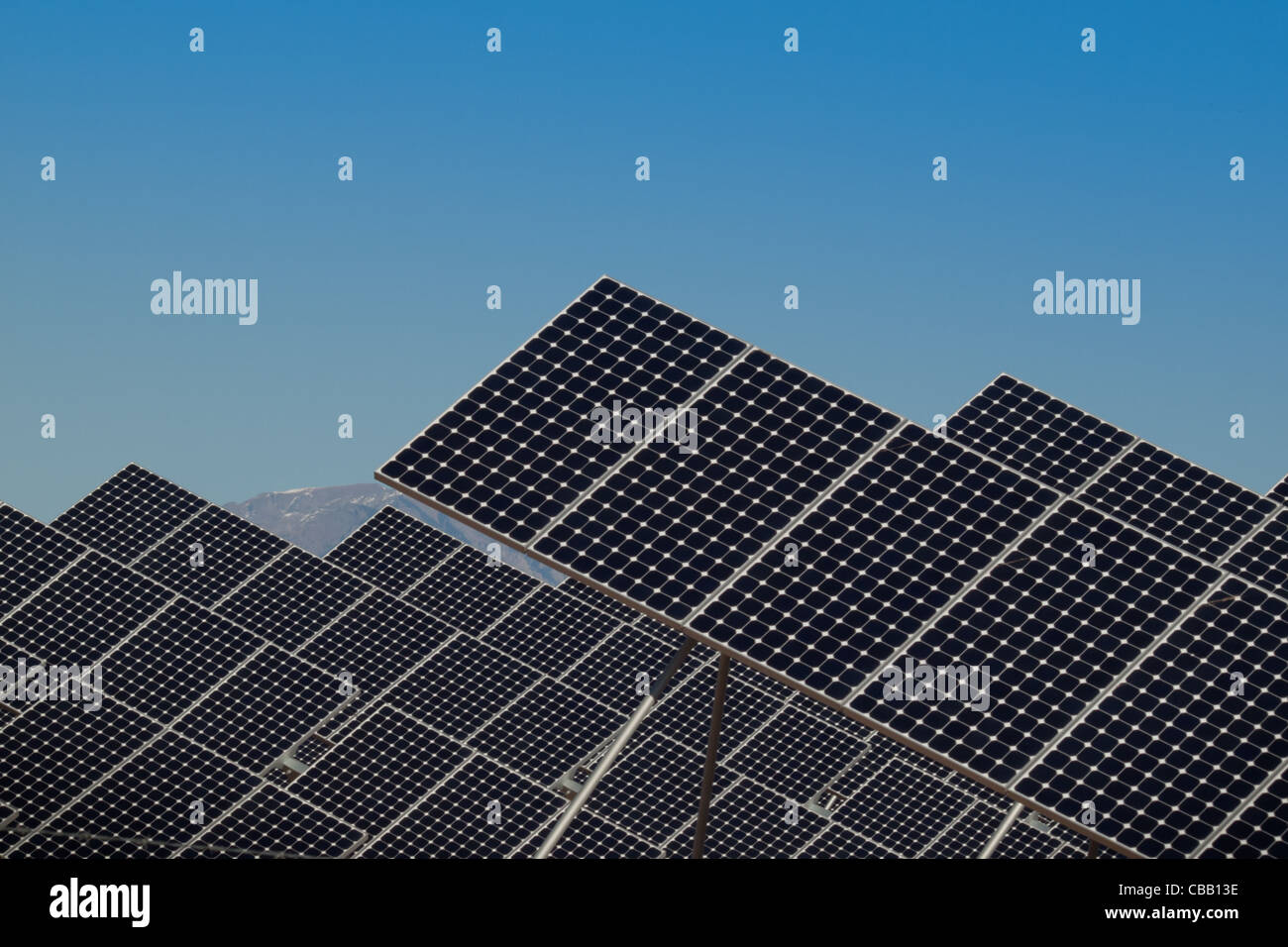 A series of large solar panels forms a symmetrical line at a power ...
