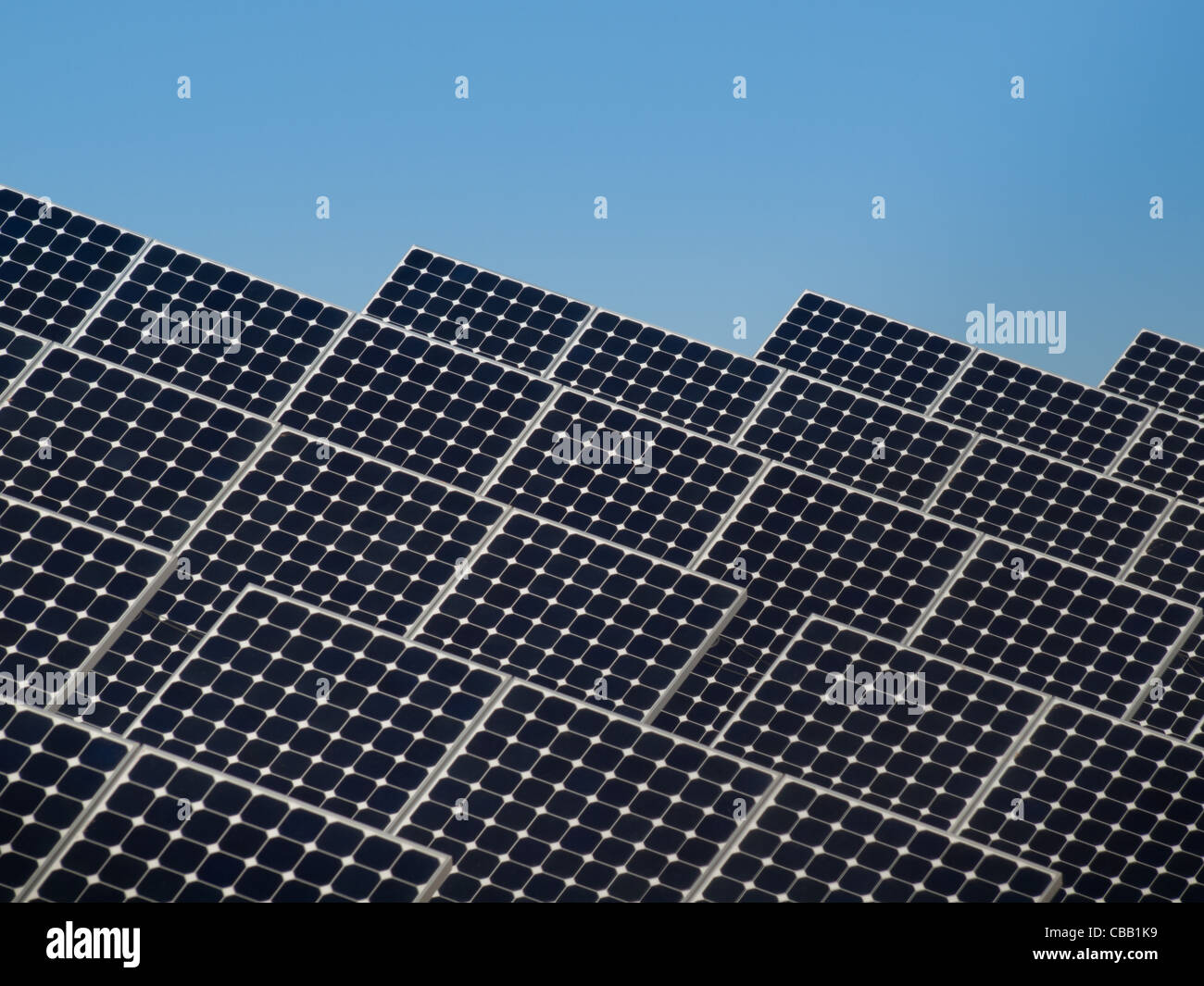 A series of large solar panels forms a symmetrical line at a power ...