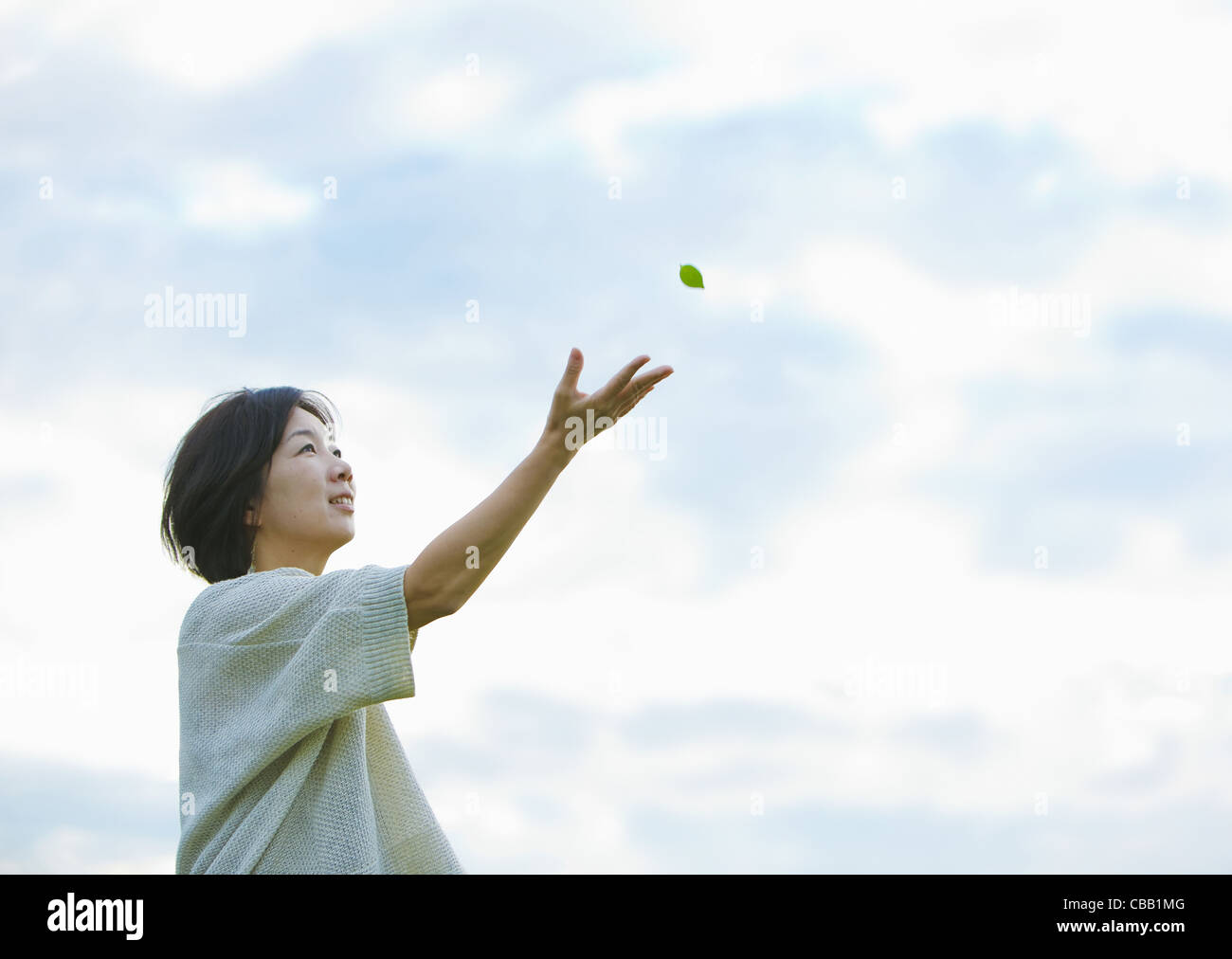 Woman reaching for leaf Stock Photo - Alamy