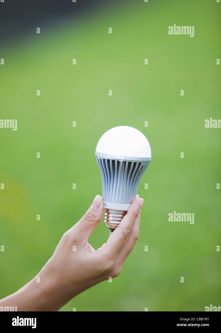 Woman's hand holding LED bulb Stock Photo - Alamy