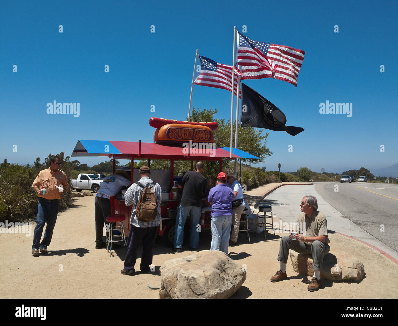 Customers line up at the Surf Dog hot dog roadside stand to grab a hot ...