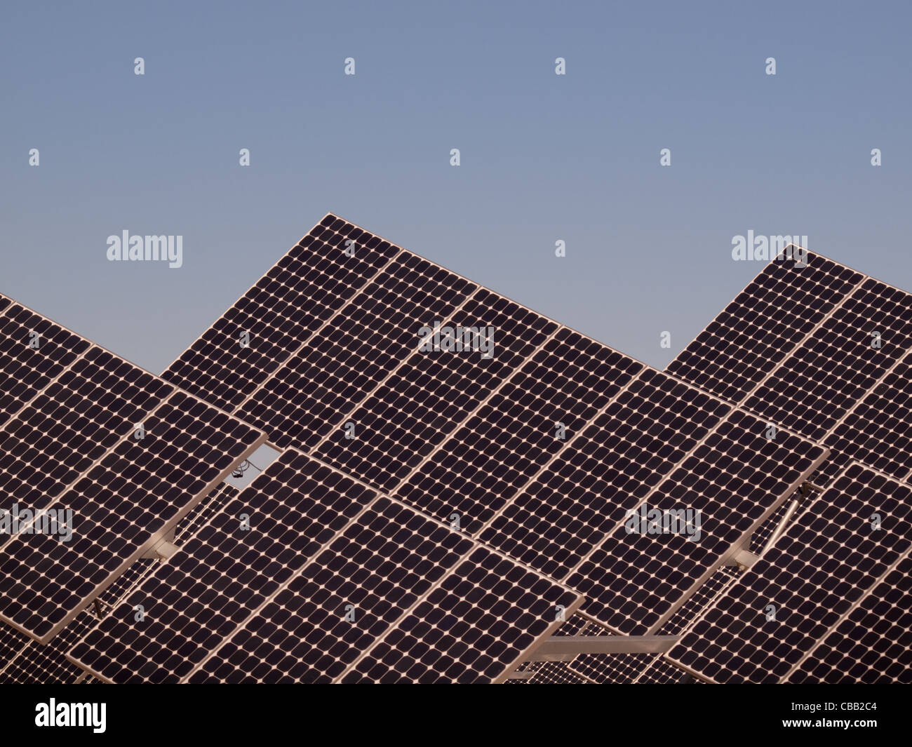 A series of large solar panels forms a symmetrical line at a power ...