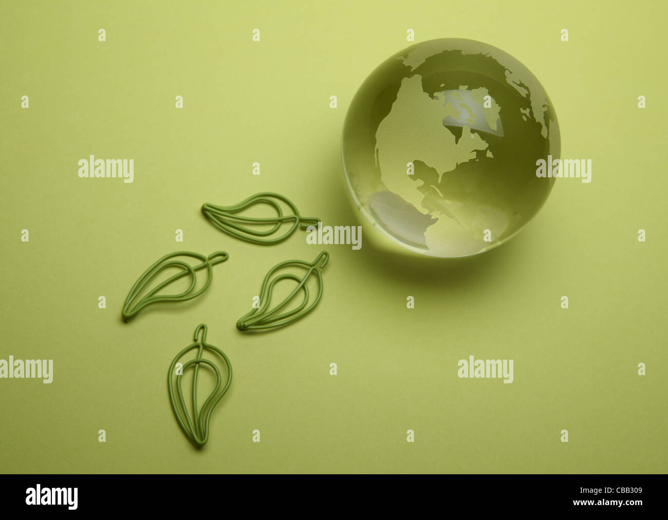 Leaf-shaped clips and glass globe Stock Photo - Alamy