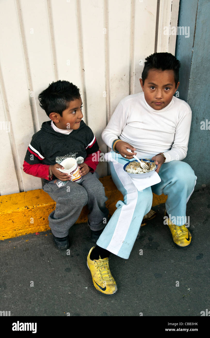 two bright eyed young Mexican older & younger brothers sitting on ...