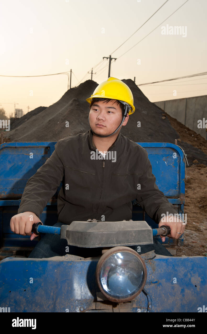 Construction worker driving a vehicle at a construction site Stock ...