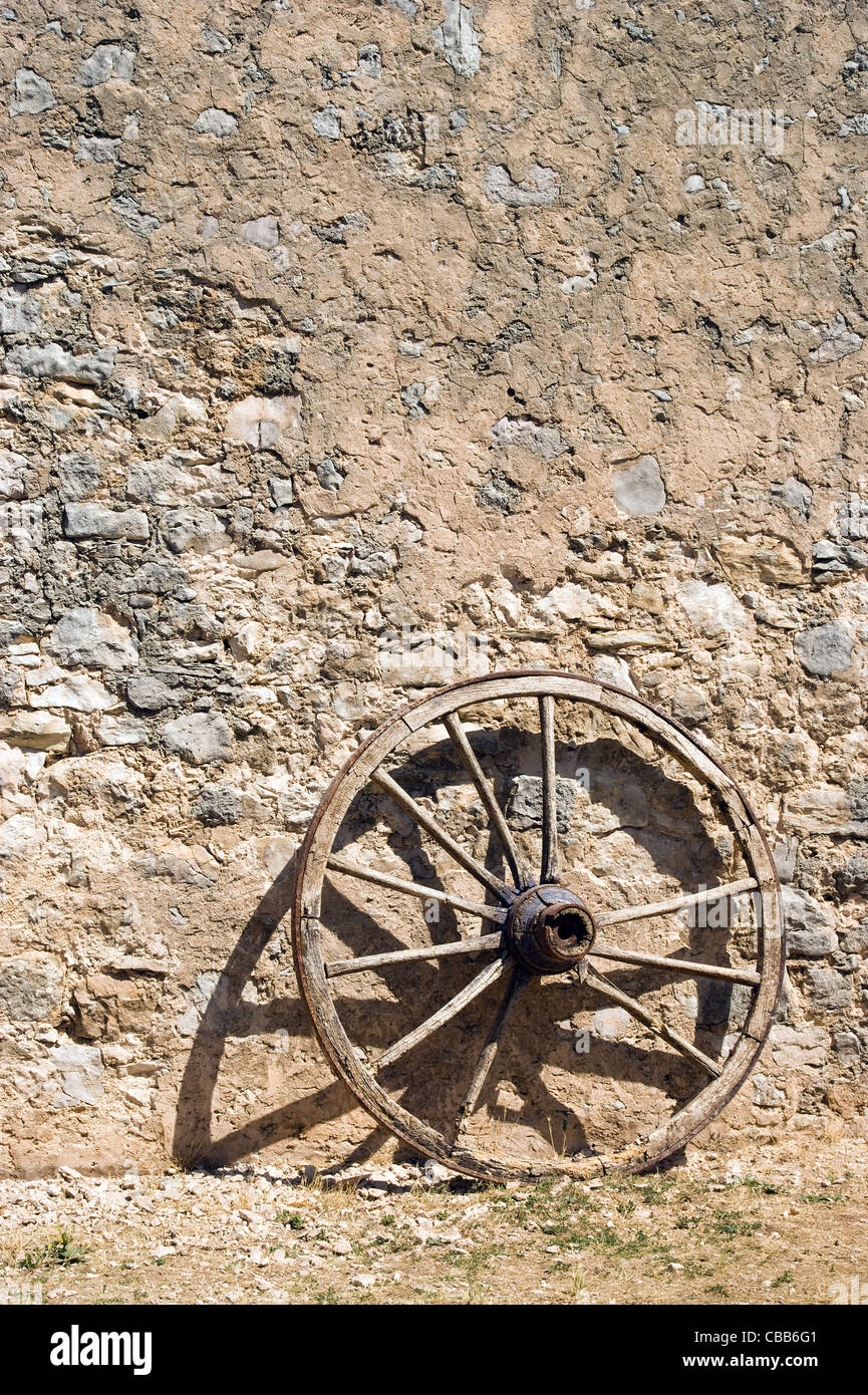 wheel at a brickwall wagon stone wall Stock Photo - Alamy