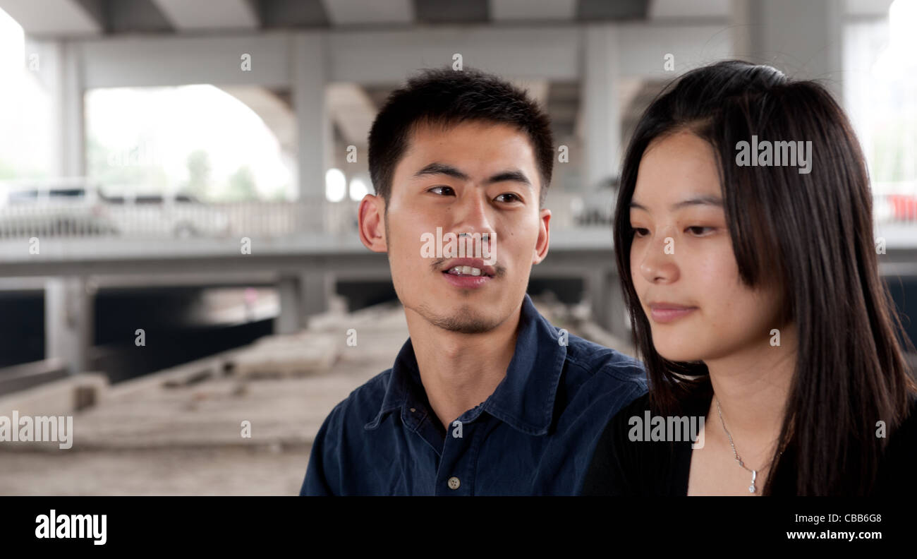 Young couple sitting and talking under a bridge Stock Photo - Alamy