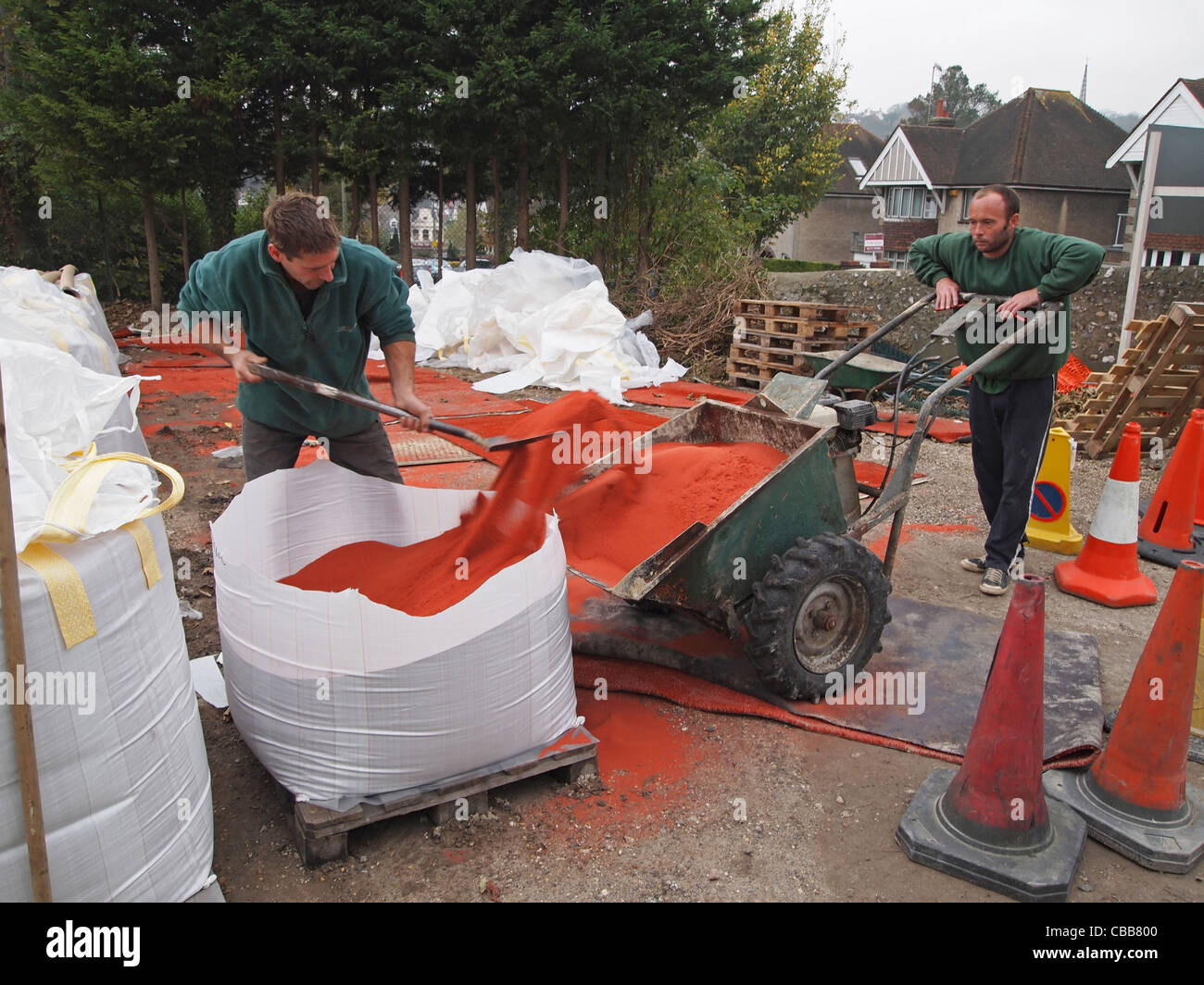 Construction of synthetic clay tennis courts - filling a barrow of the ...