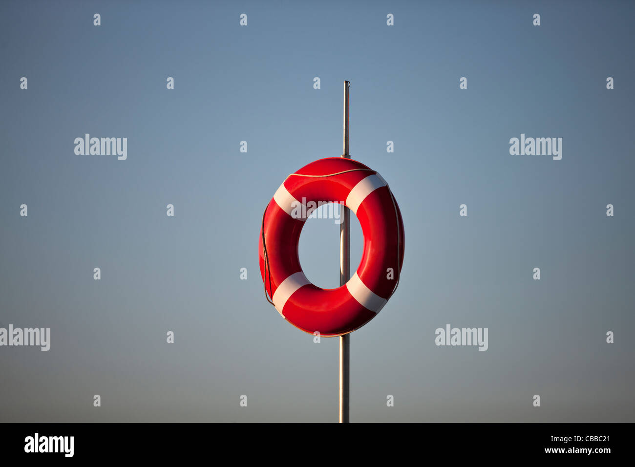 A red life ring hanging on a post Stock Photo - Alamy