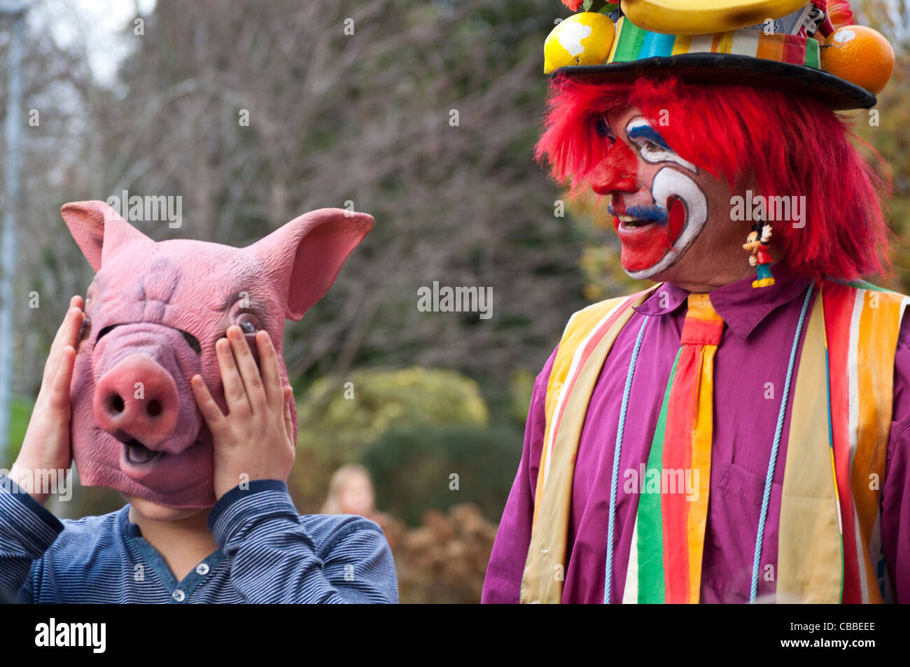 Clown entertains crowd with rubber pig's head on child during Criccieth ...