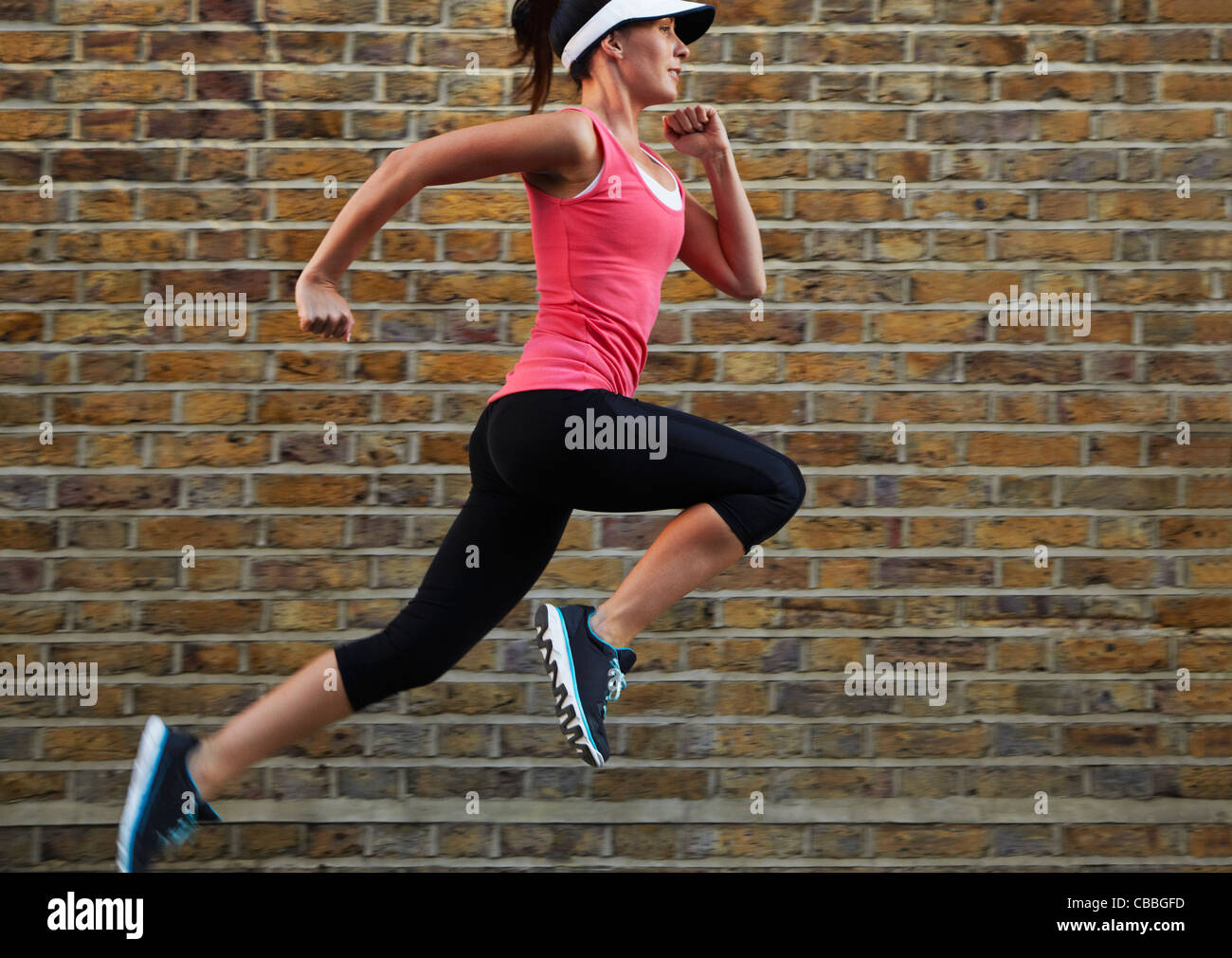 Woman running on city street Stock Photo - Alamy