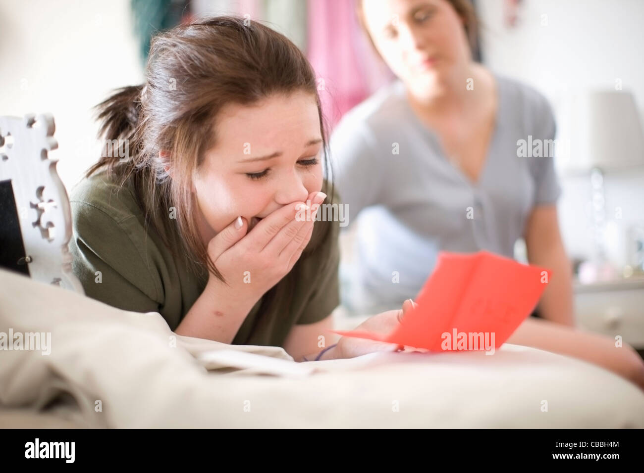 Crying teenage girl reading letter Stock Photo - Alamy