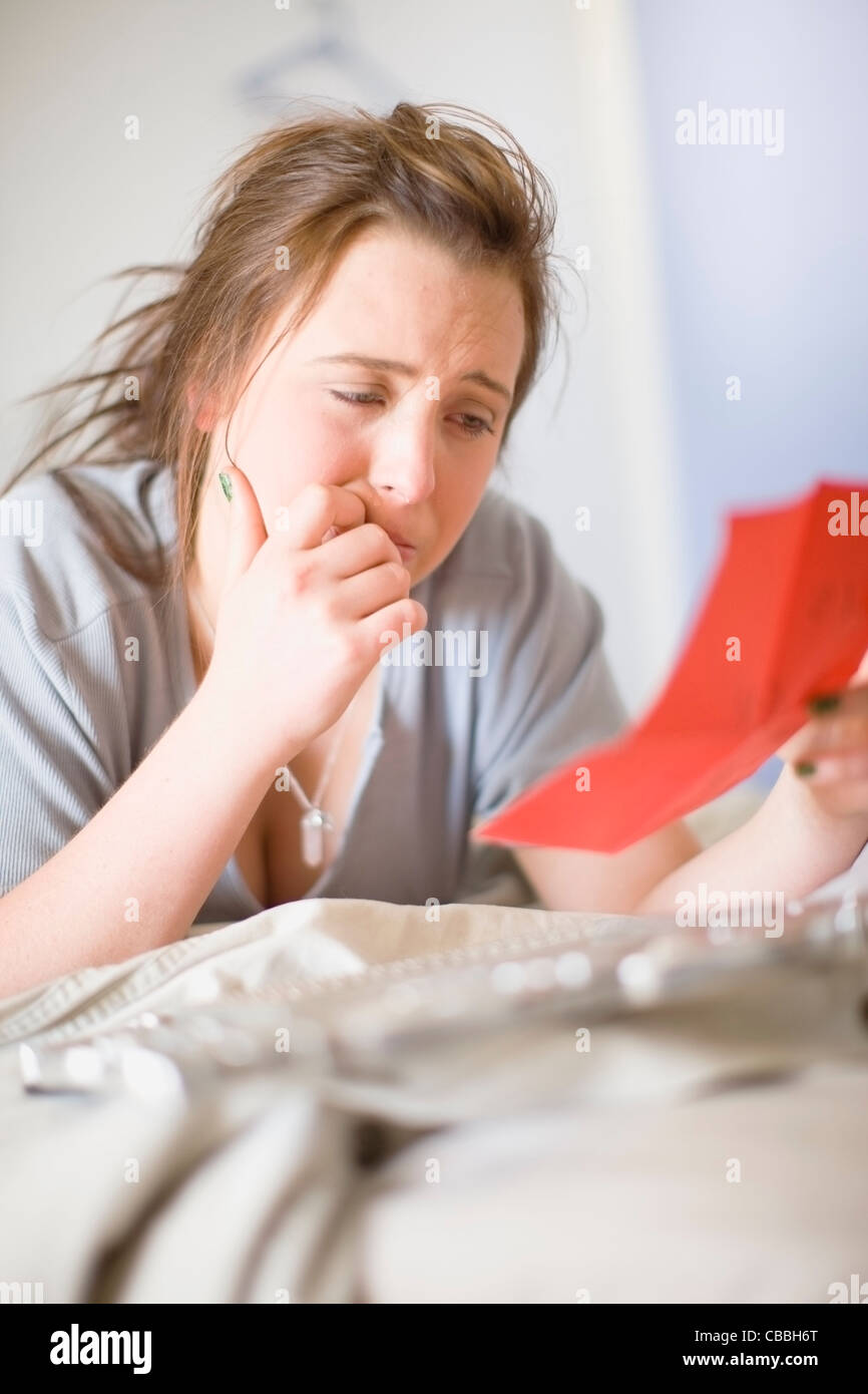 Crying teenage girl reading letter Stock Photo - Alamy