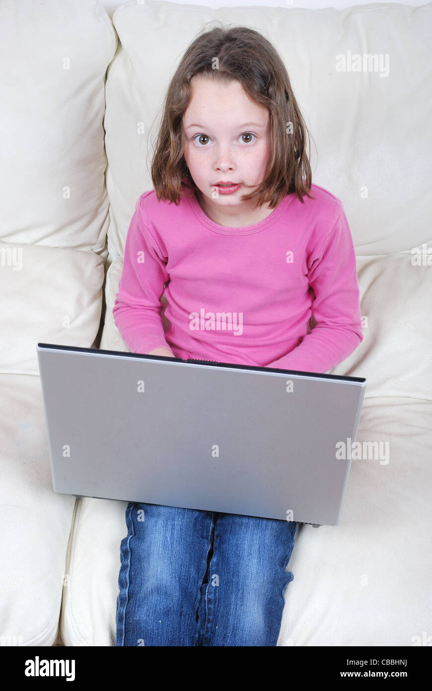 Girl sitting on the sofa and using laptop Stock Photo - Alamy