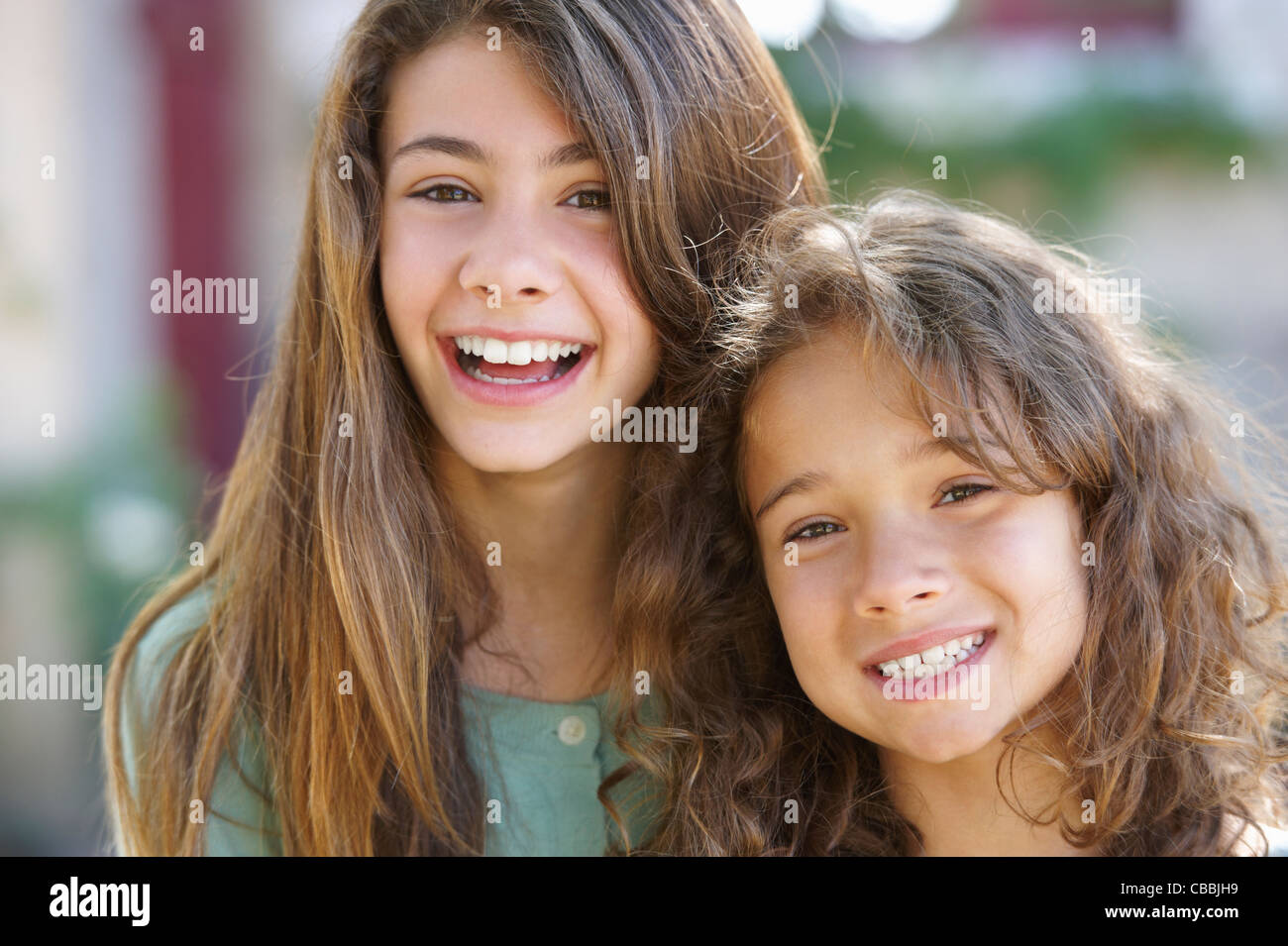 Smiling sisters hugging outdoors Stock Photo - Alamy