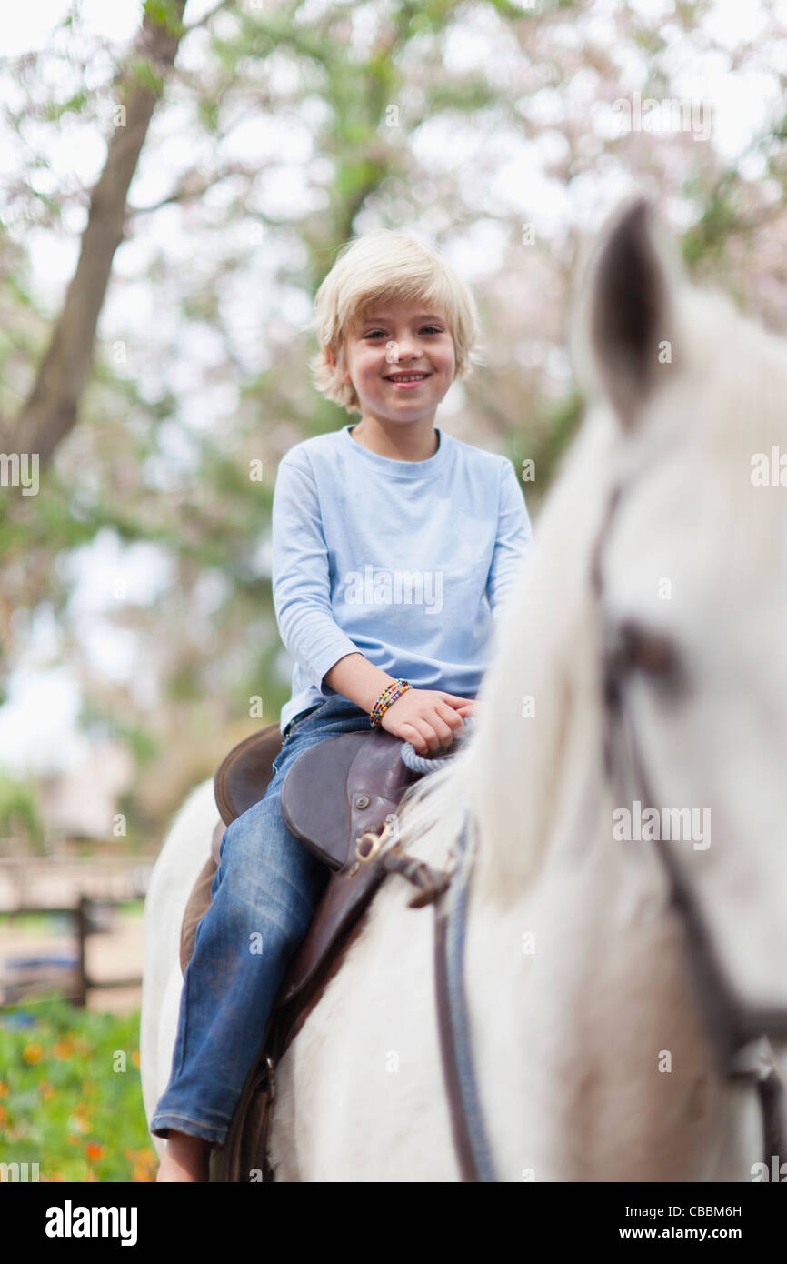 Smiling boy riding horse Stock Photo - Alamy