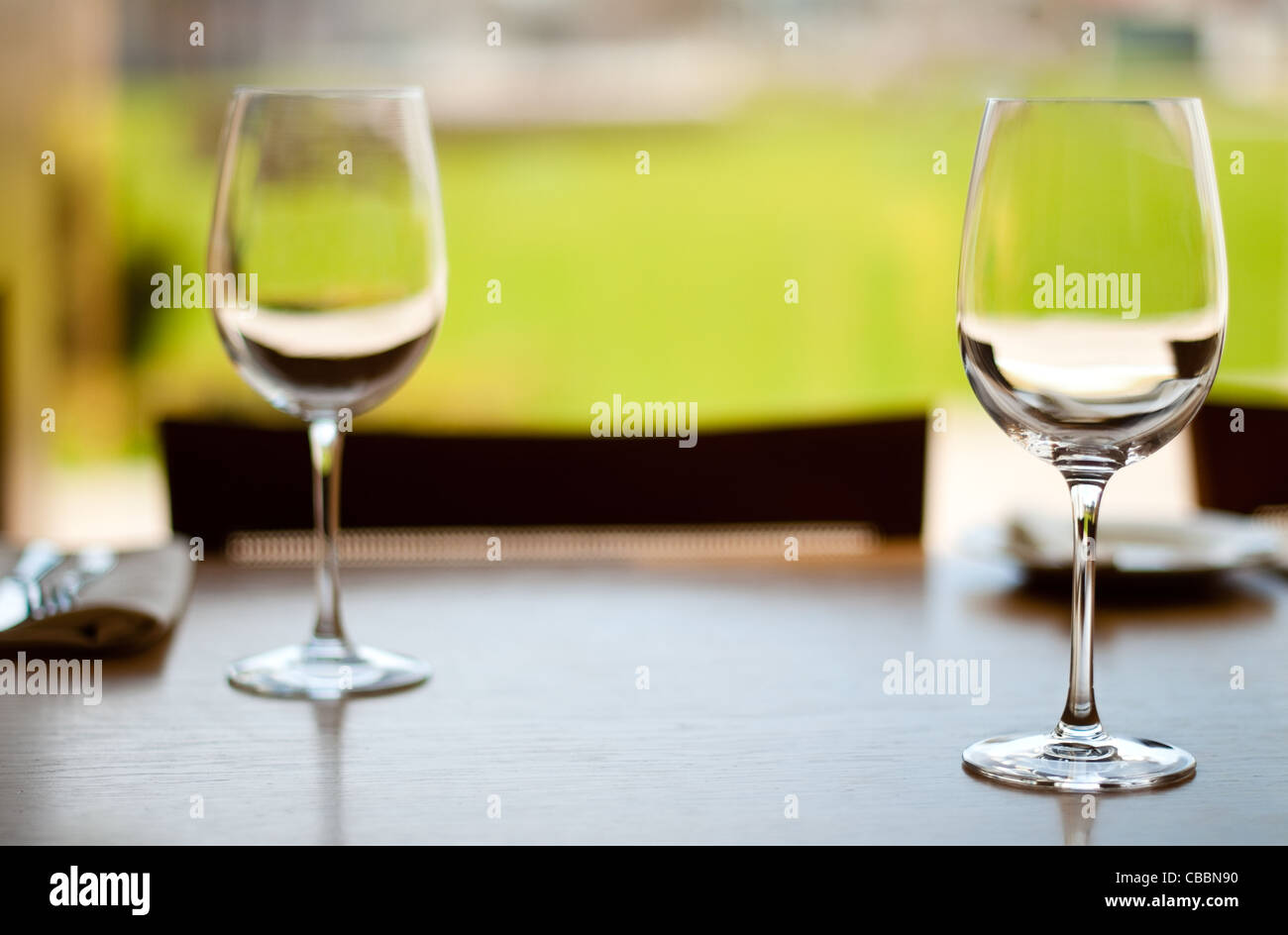 two empty glass goblets on wooden table in restaurant (extremely ...