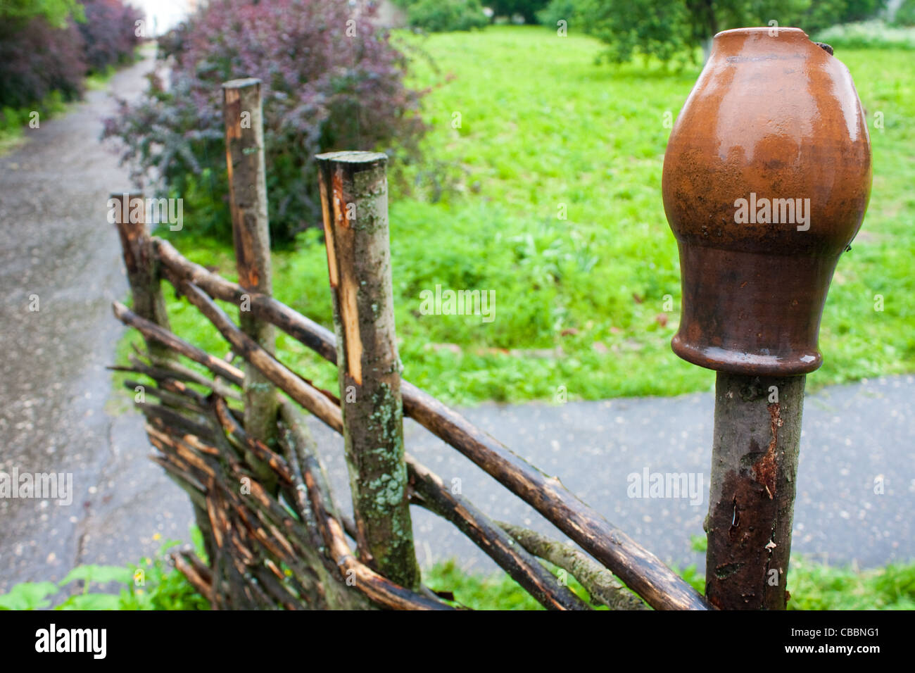 pot on wooden farm fence with grass and tree in background Stock Photo ...