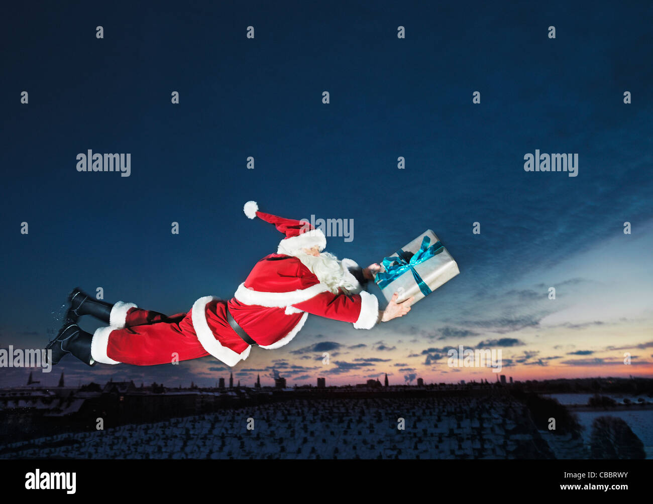 Santa Claus flying with wrapped gift Stock Photo - Alamy