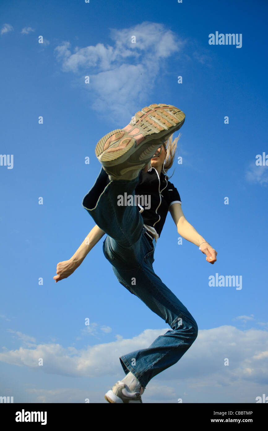 girl jumping outside with blue sky in background Stock Photo - Alamy