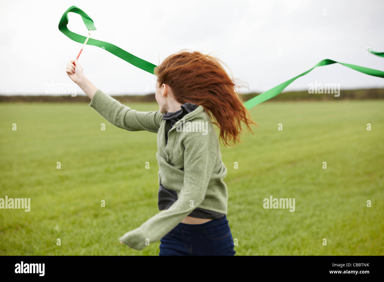 Teenage girl playing with ribbon Stock Photo - Alamy