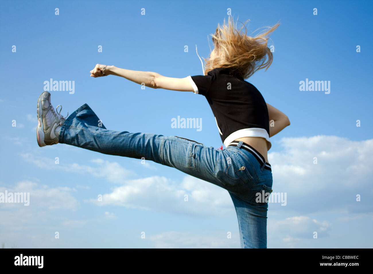 girl jumping outside with blue sky in background Stock Photo - Alamy