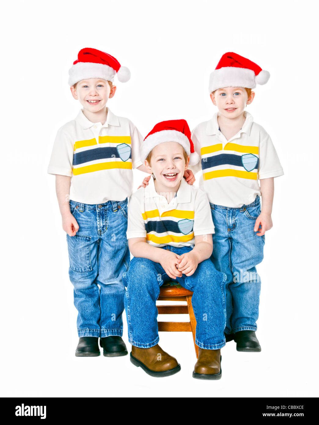 Three young boys stusio portrait wearing santa hats Stock Photo - Alamy