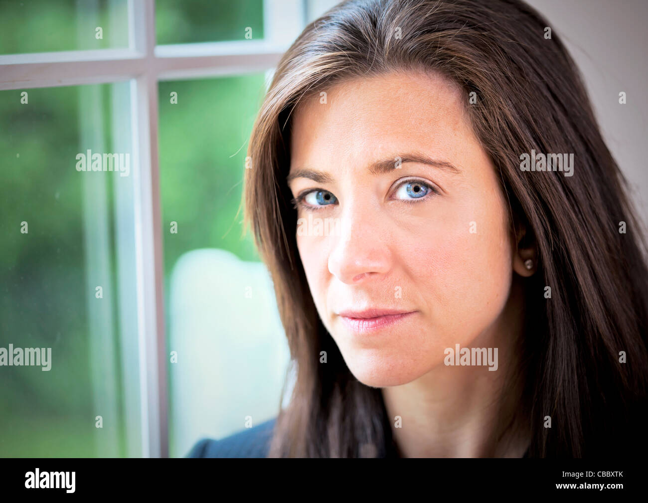 Serious woman standing window hi-res stock photography and images - Alamy