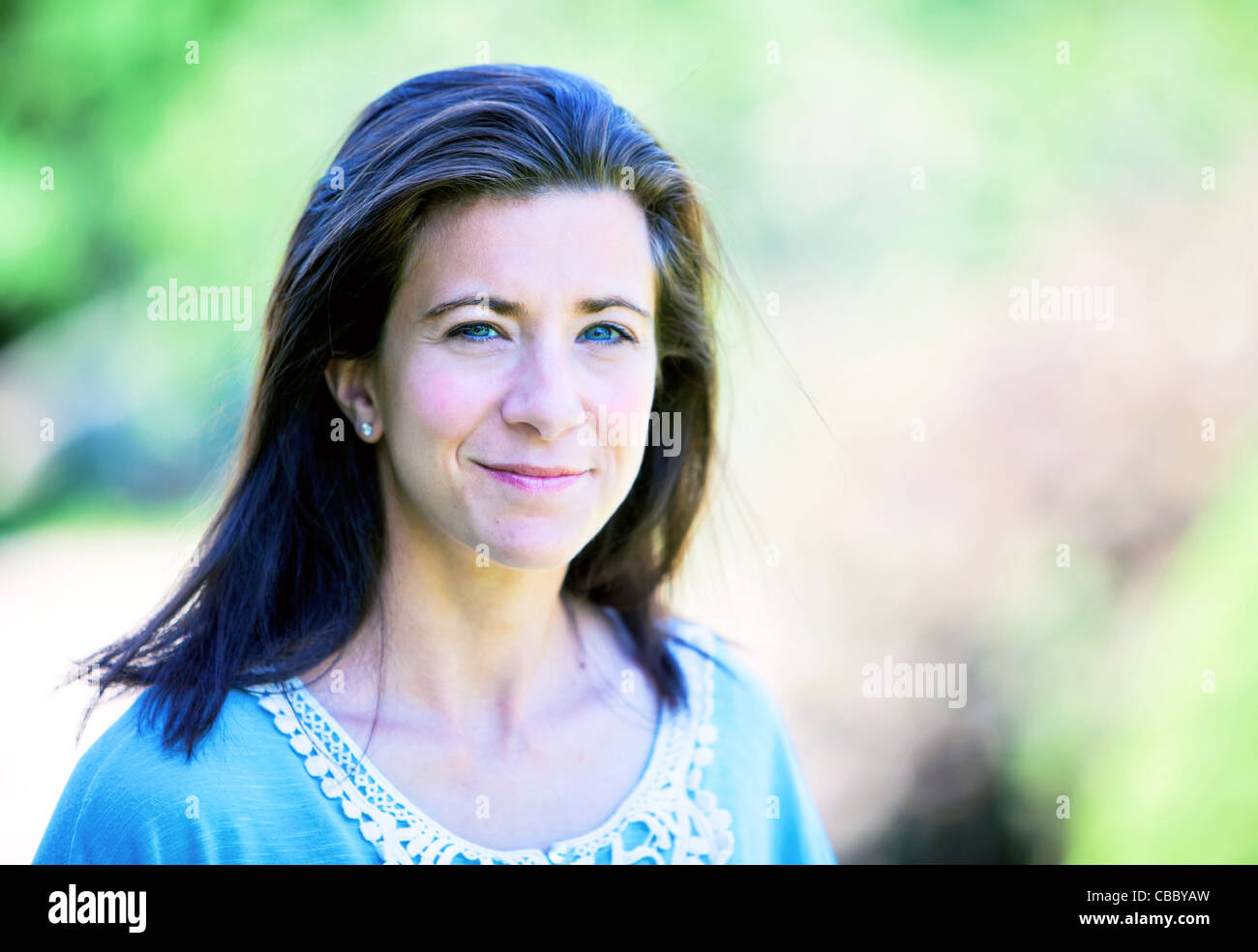 Happy woman standing outside portrait with green background Stock Photo ...