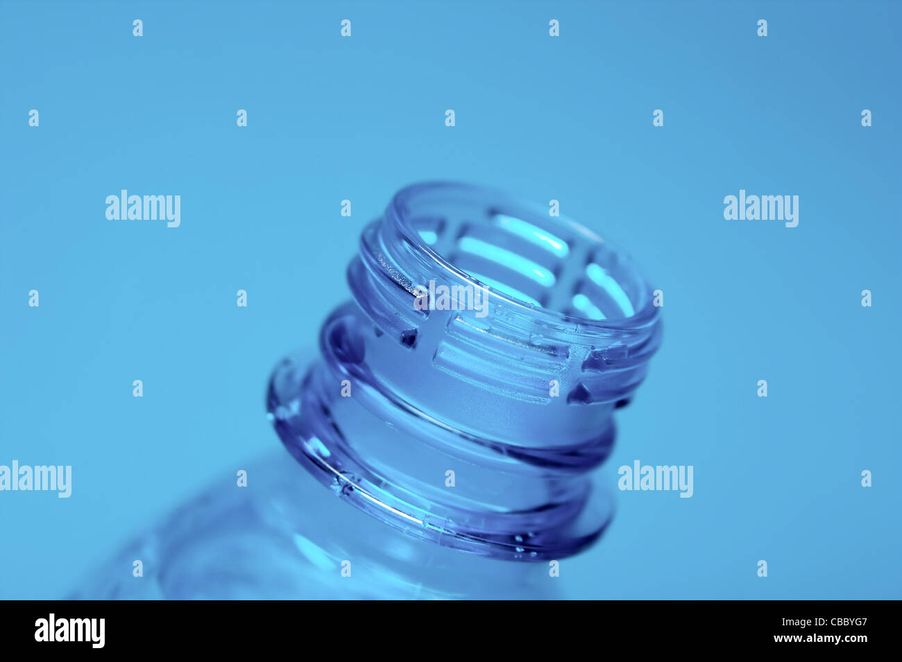 Neck of an open plastic water bottle on blue background Stock Photo - Alamy