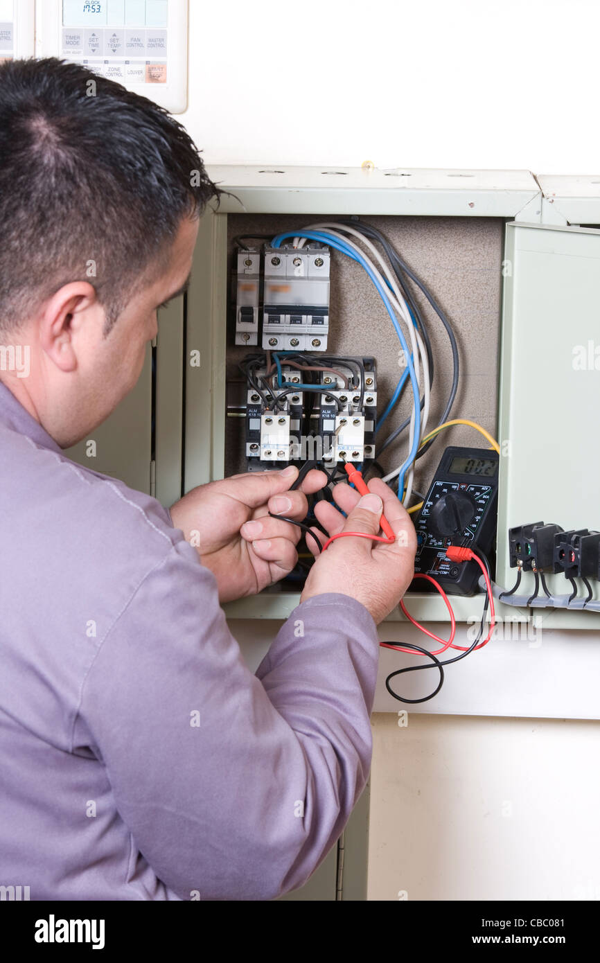Electrician working on a panel Stock Photo - Alamy