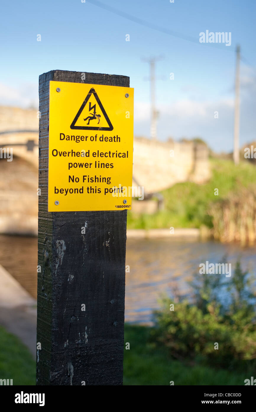 Danger of death sign next to a river and small bridge. overhead ...