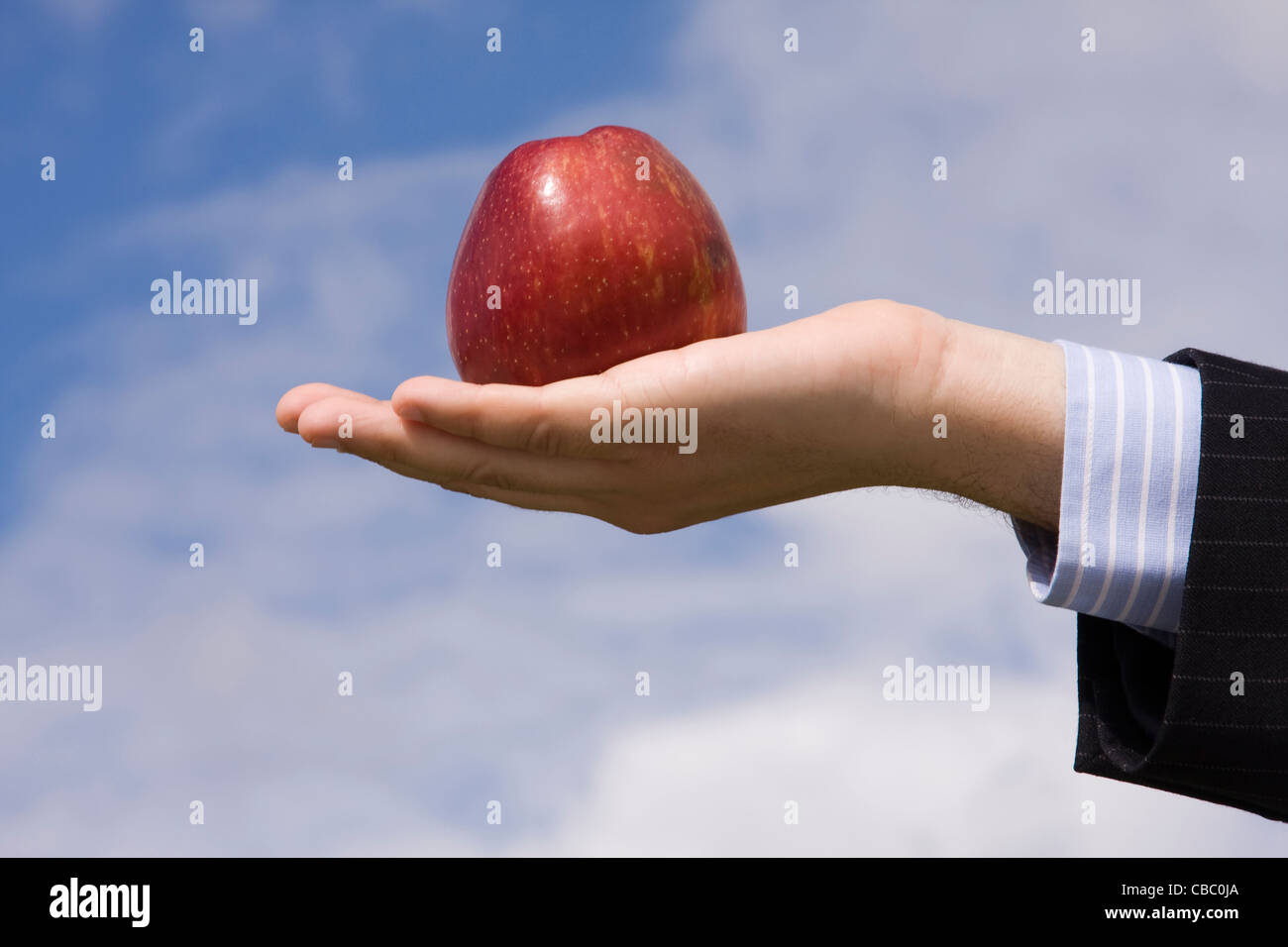 a businessman hand holding an apple as symbol of business temptation ...