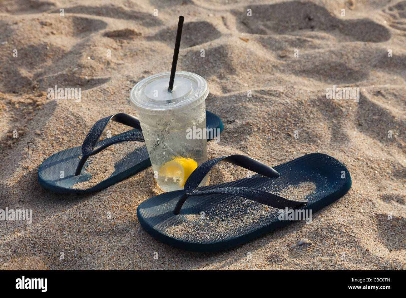 Slippers on sand at beach Stock Photo - Alamy